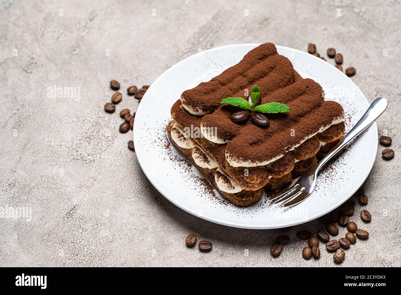 Classic tiramisu dessert on ceramic plate on concrete background Stock ...