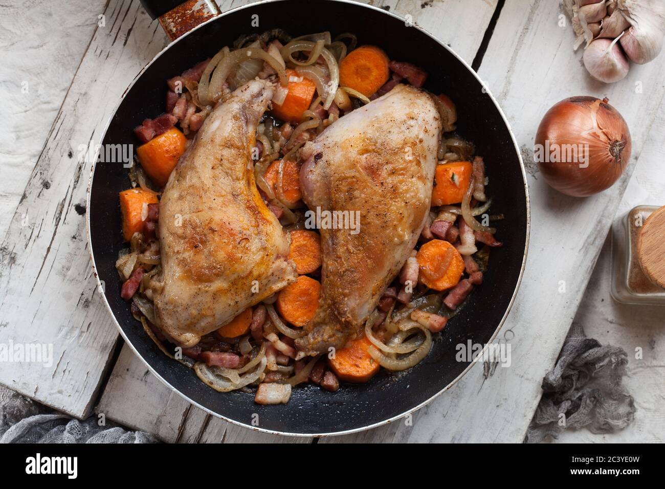 Fried rabbit legs on frying pan with vegetables and herbs Stock Photo ...