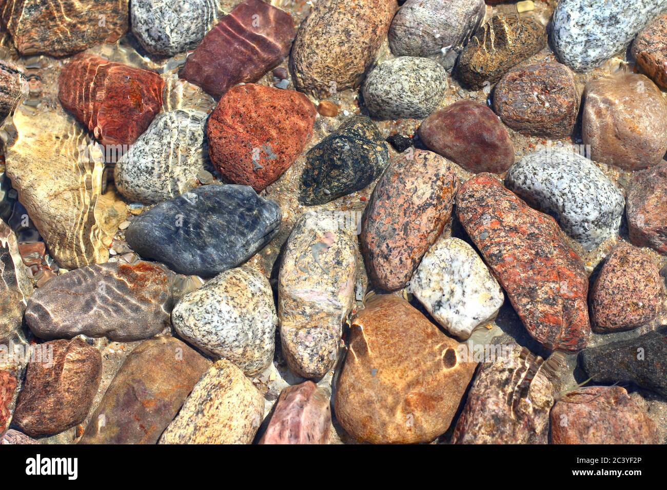 Colourful stones in water Stock Photo - Alamy