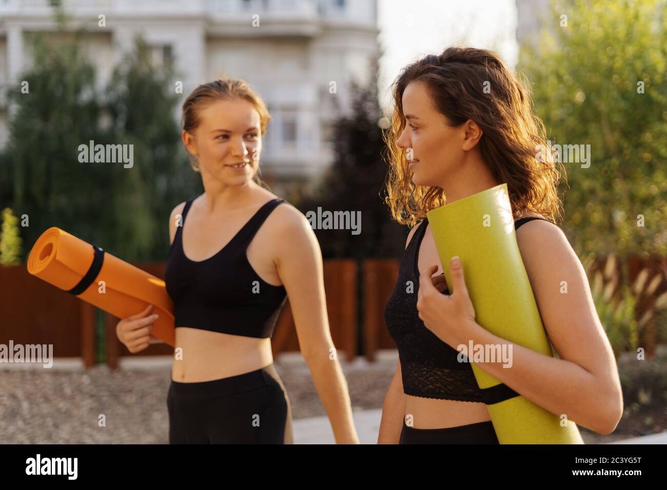 Two young beautiful women in sportswear going to do sports training ...