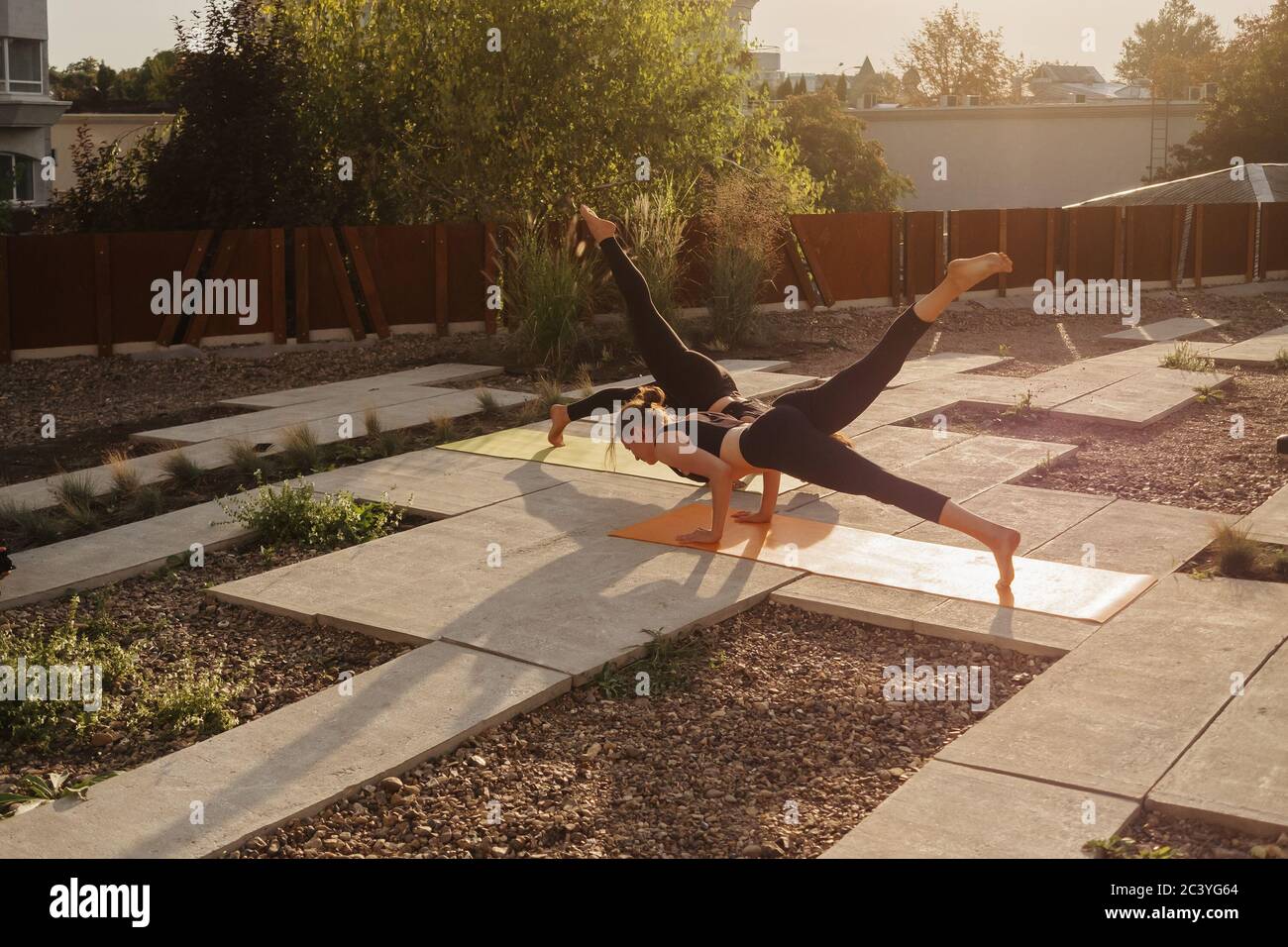 Two young girls practicing stretching and yoga workout exercise ...