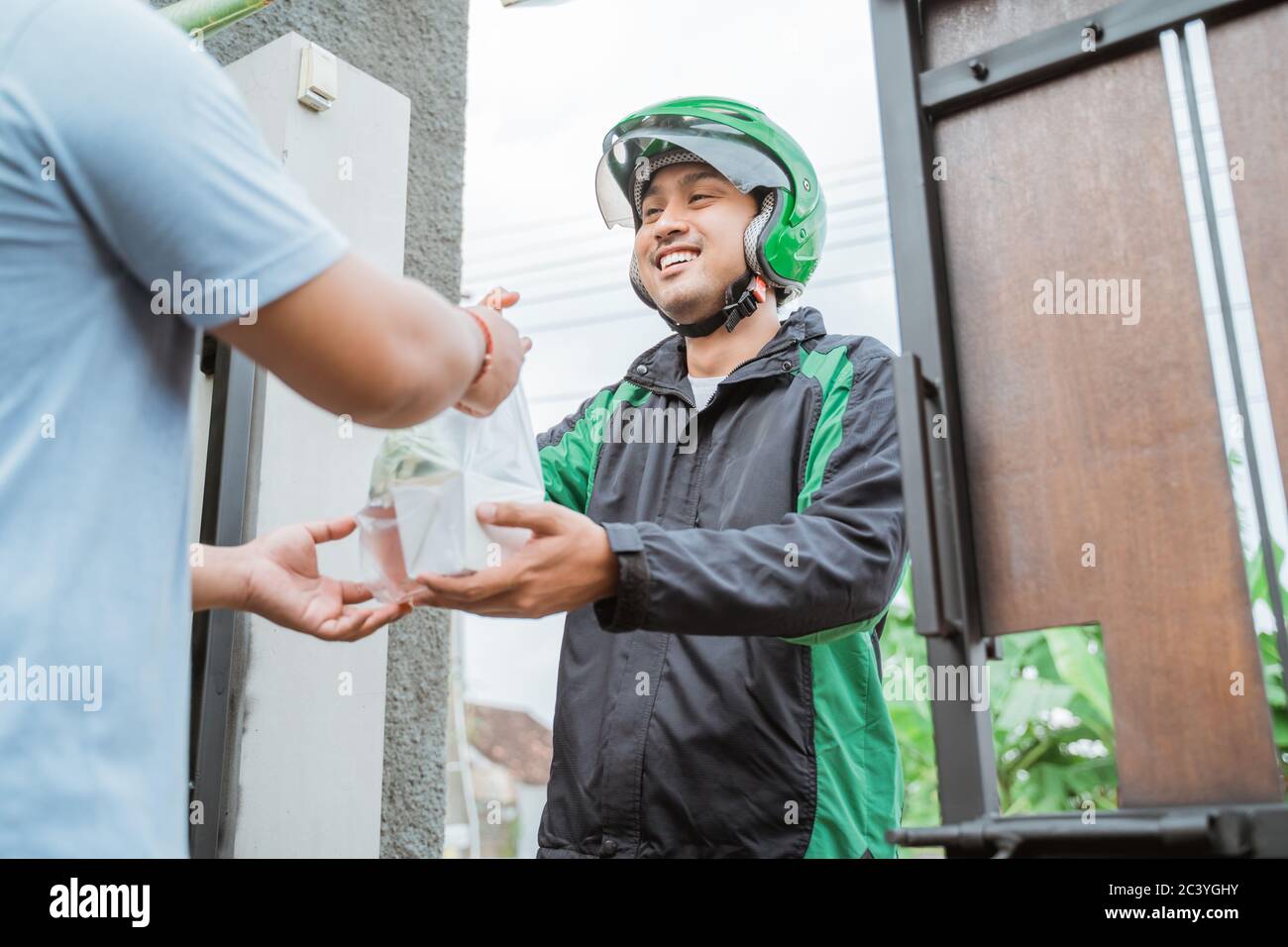 man ordering food online and receive the order at home delivered by ...
