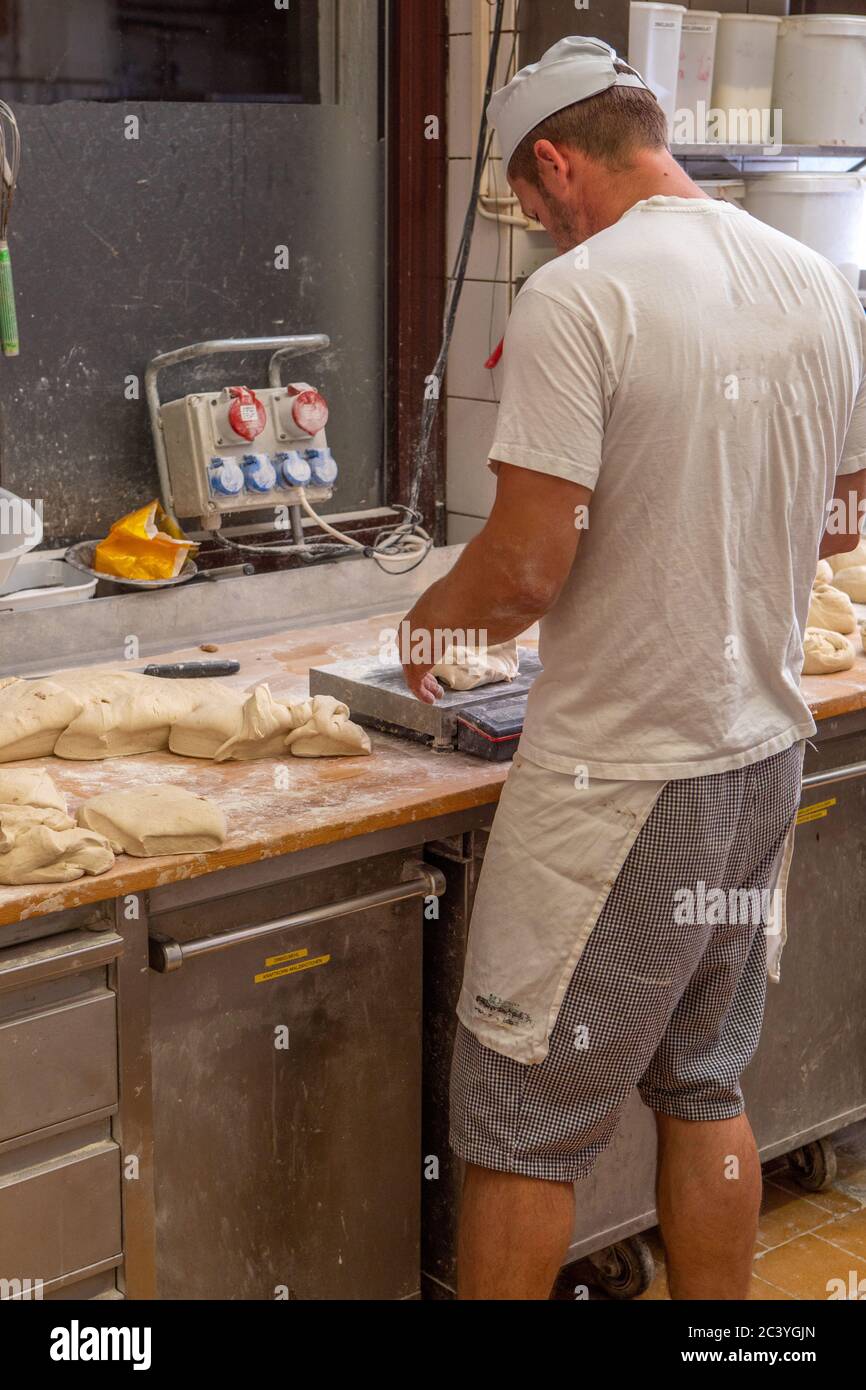 a baker portions the bread dough into equally sized pieces Stock Photo ...