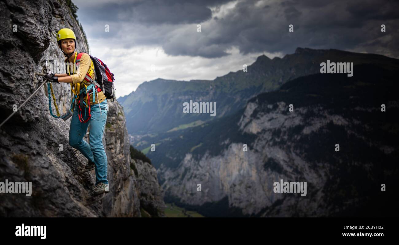 Young, male climber on a via ferrata route - climbing on a rock in ...