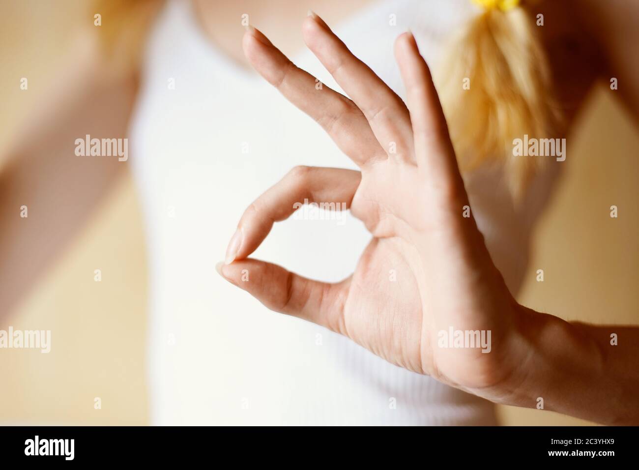 Female hand shows ok sign on the background of the young body in a ...