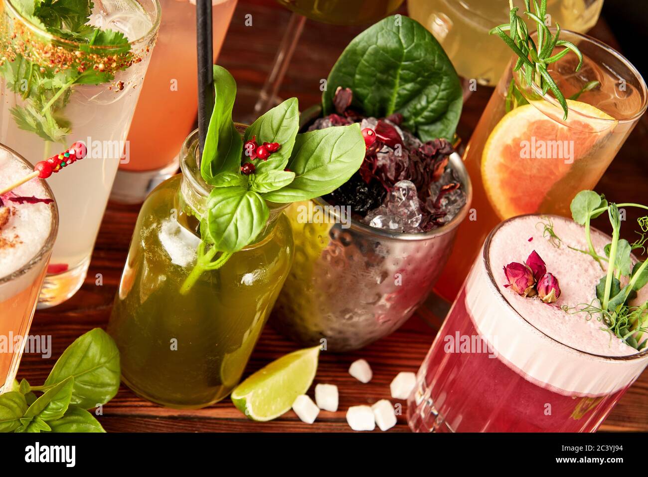 Colorful cocktails in different glasses on wooden table Stock Photo - Alamy