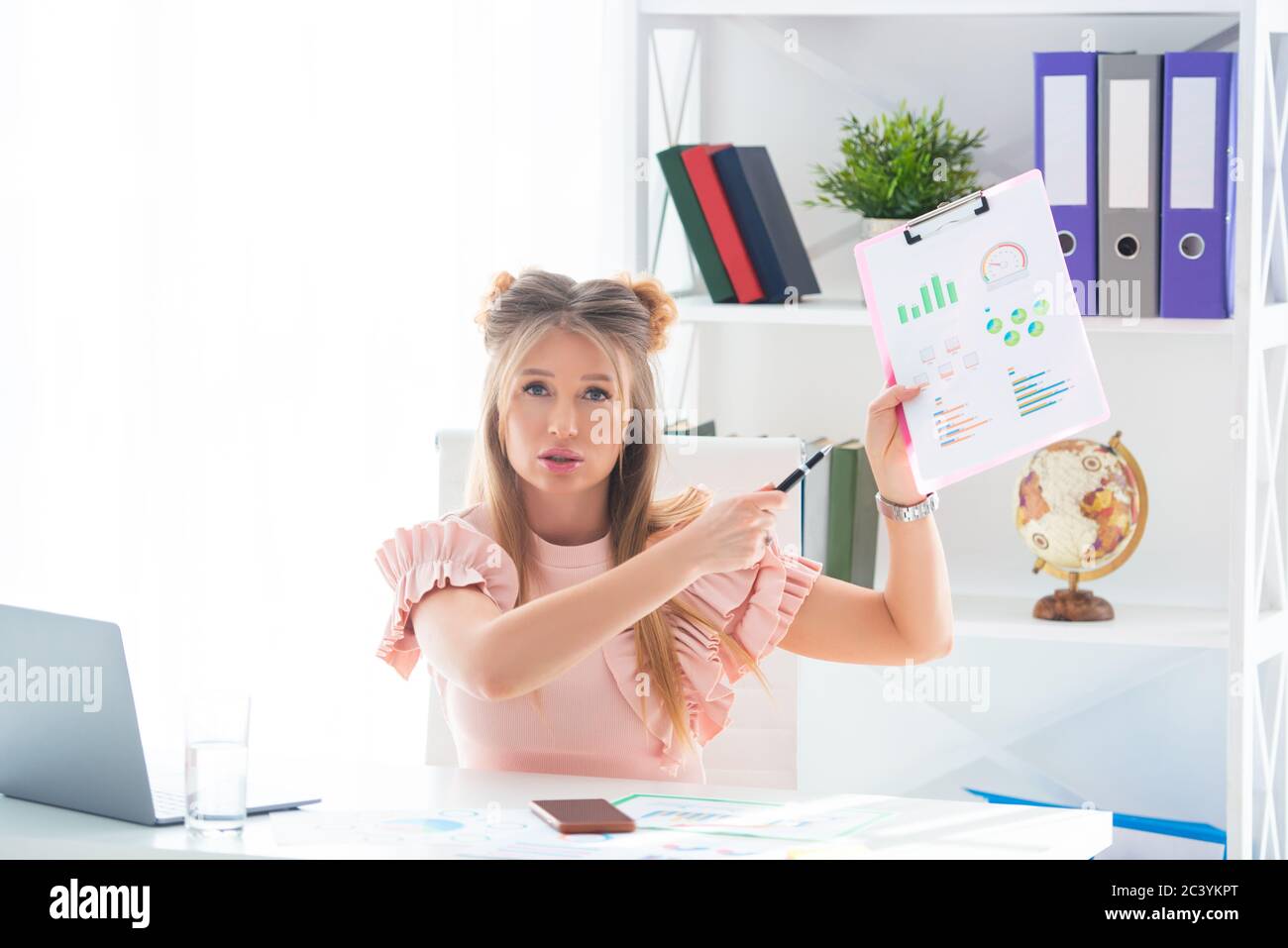 Successful business woman working in an office at a table, showing a ...