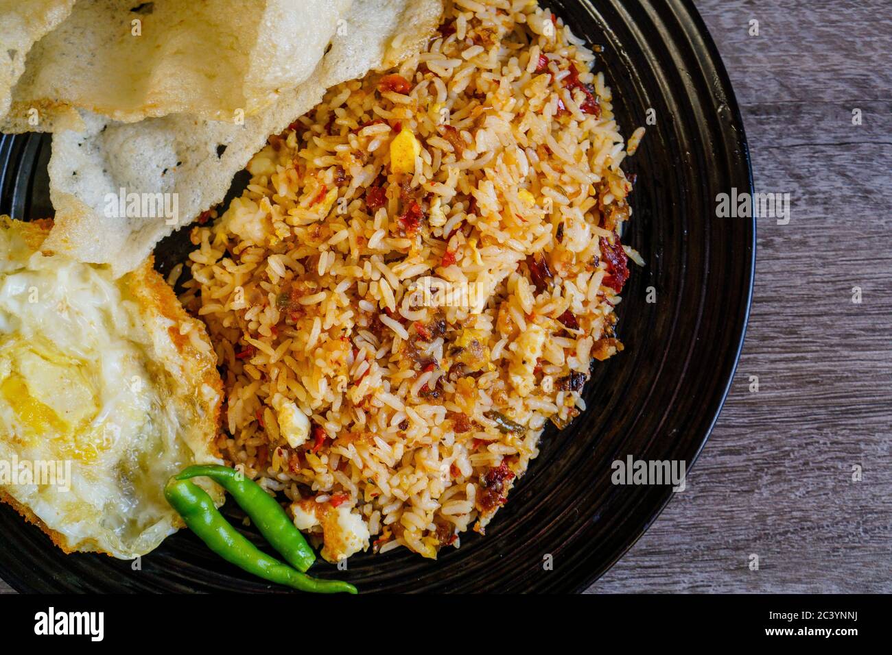 Spicy fried rice with dried chilli with fried egg and fish cracker ...