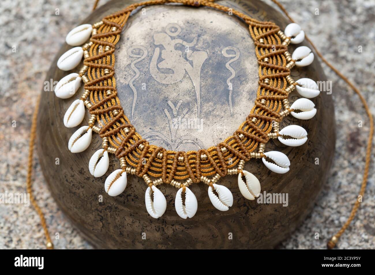 Macrame boho necklace with white shells on vintage metal background ...