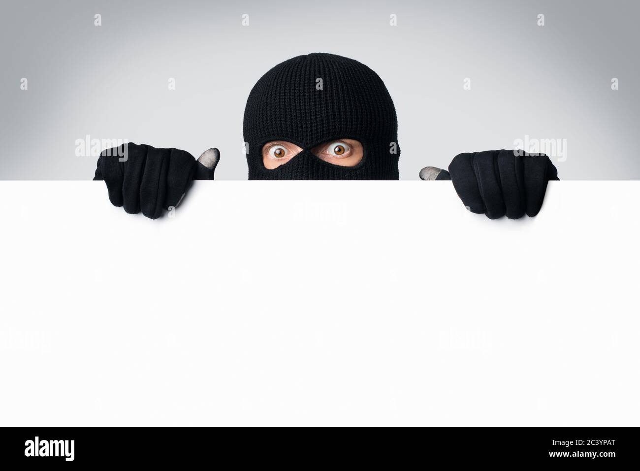 Masked thief peeking out white blank board Stock Photo - Alamy