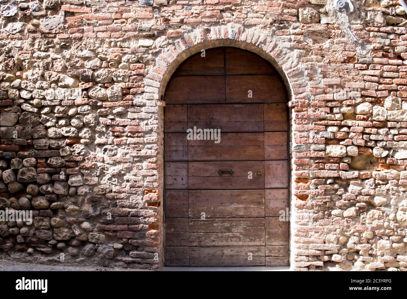 Ancient typical Italian house facade with brown door and brick wall ...