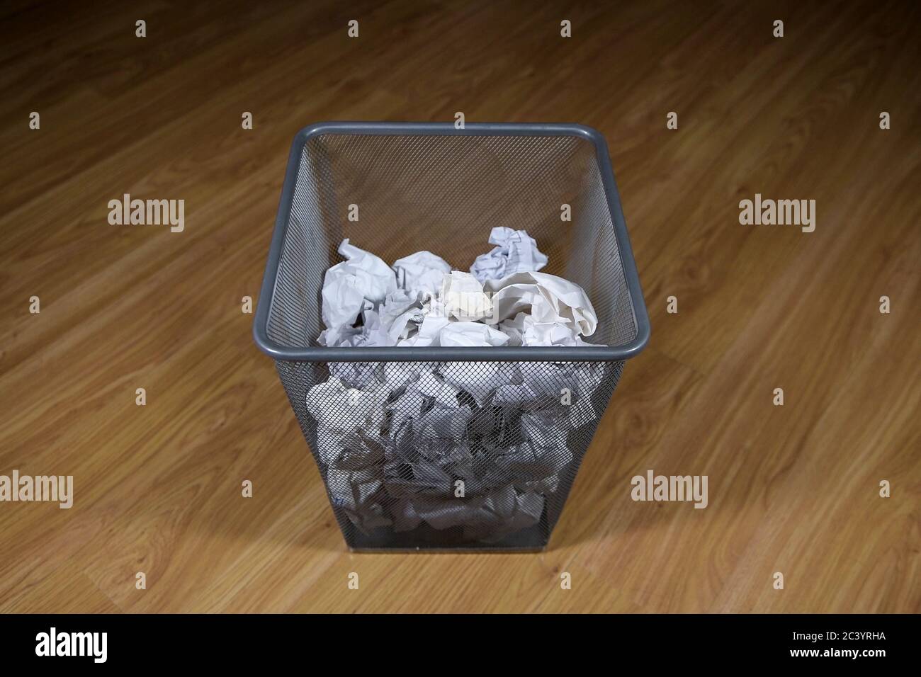 A basket of paper trash is on the floor Stock Photo - Alamy