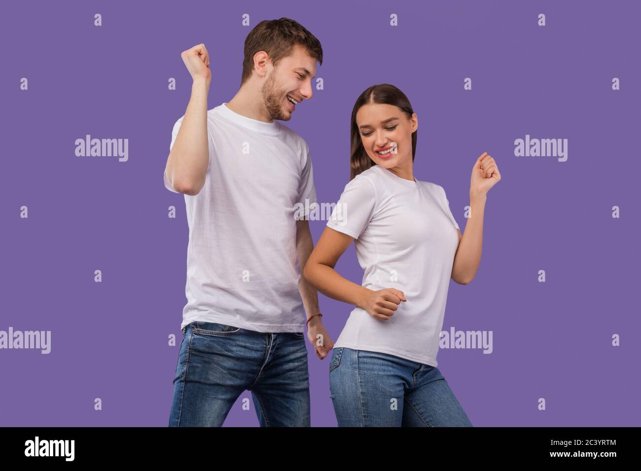 Happy partners dancing on pastel purple studio background Stock Photo ...