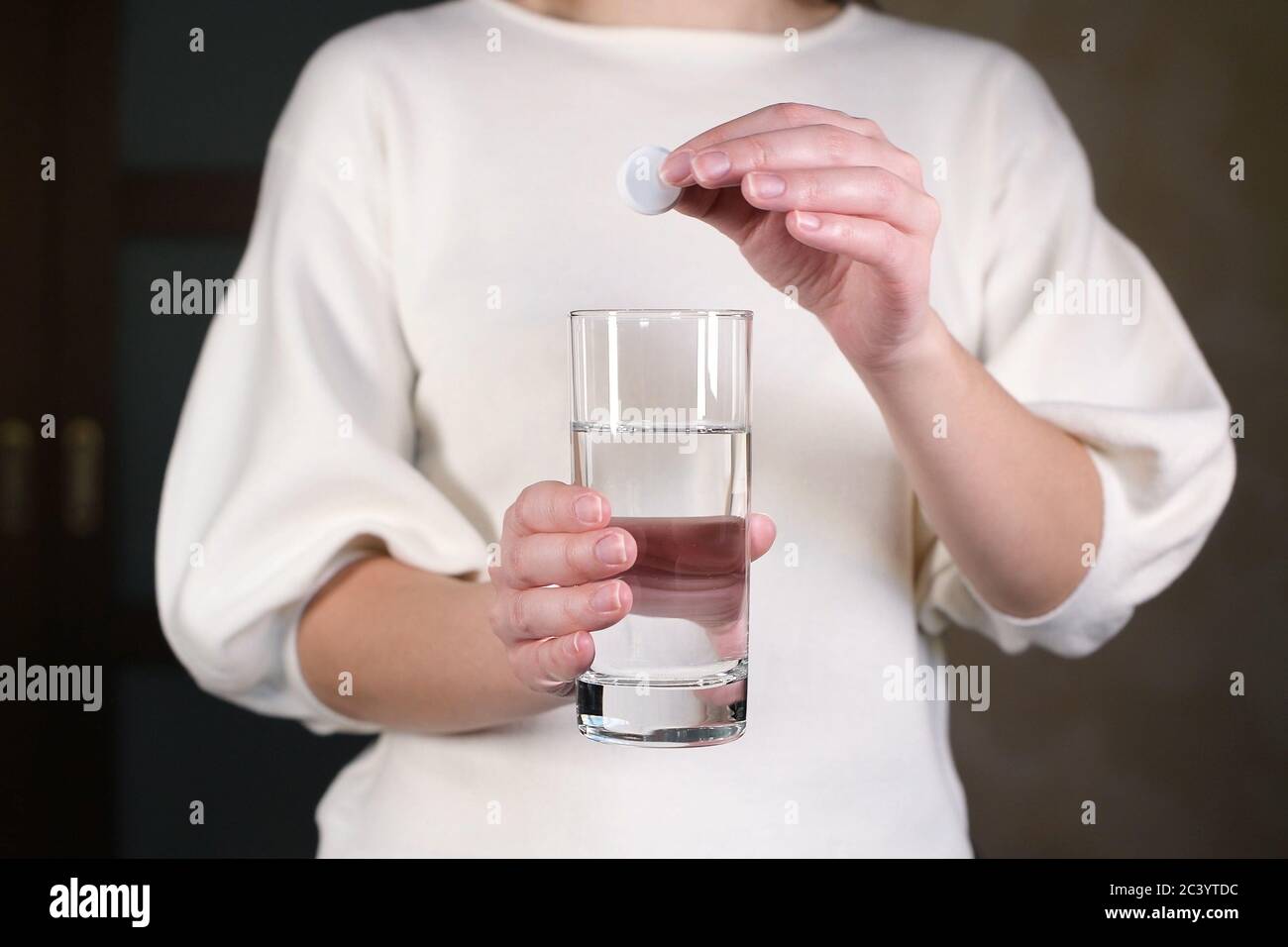 girl throws soluble effervescent tablets into a glass with water ...