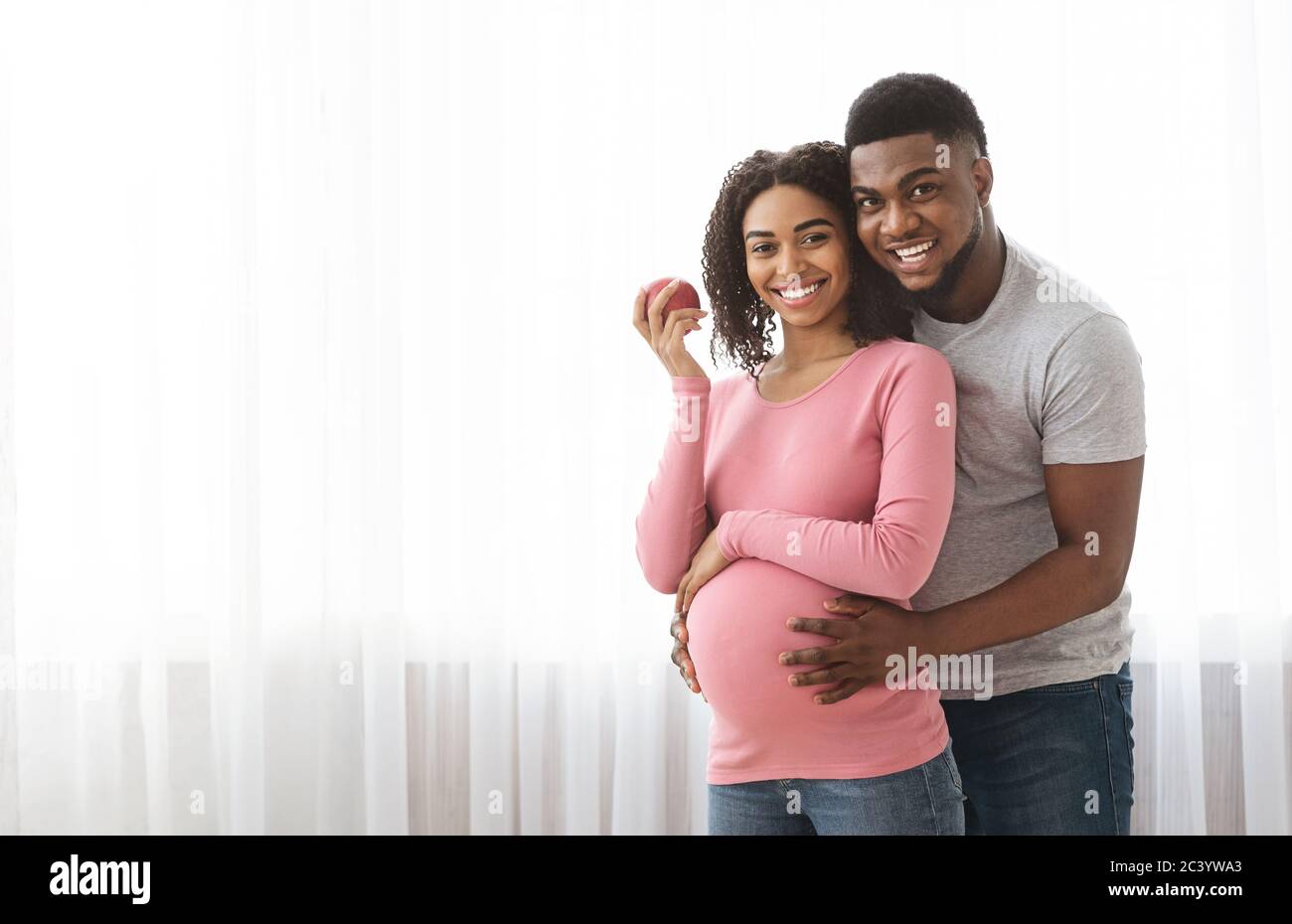 Happy expecting couple posing next to window at home Stock Photo - Alamy
