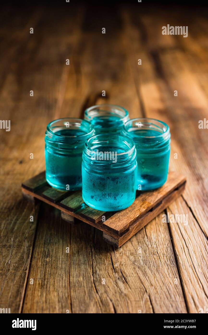 Blue colored alcoholic shooters, or shot drinks on wooden table Stock ...