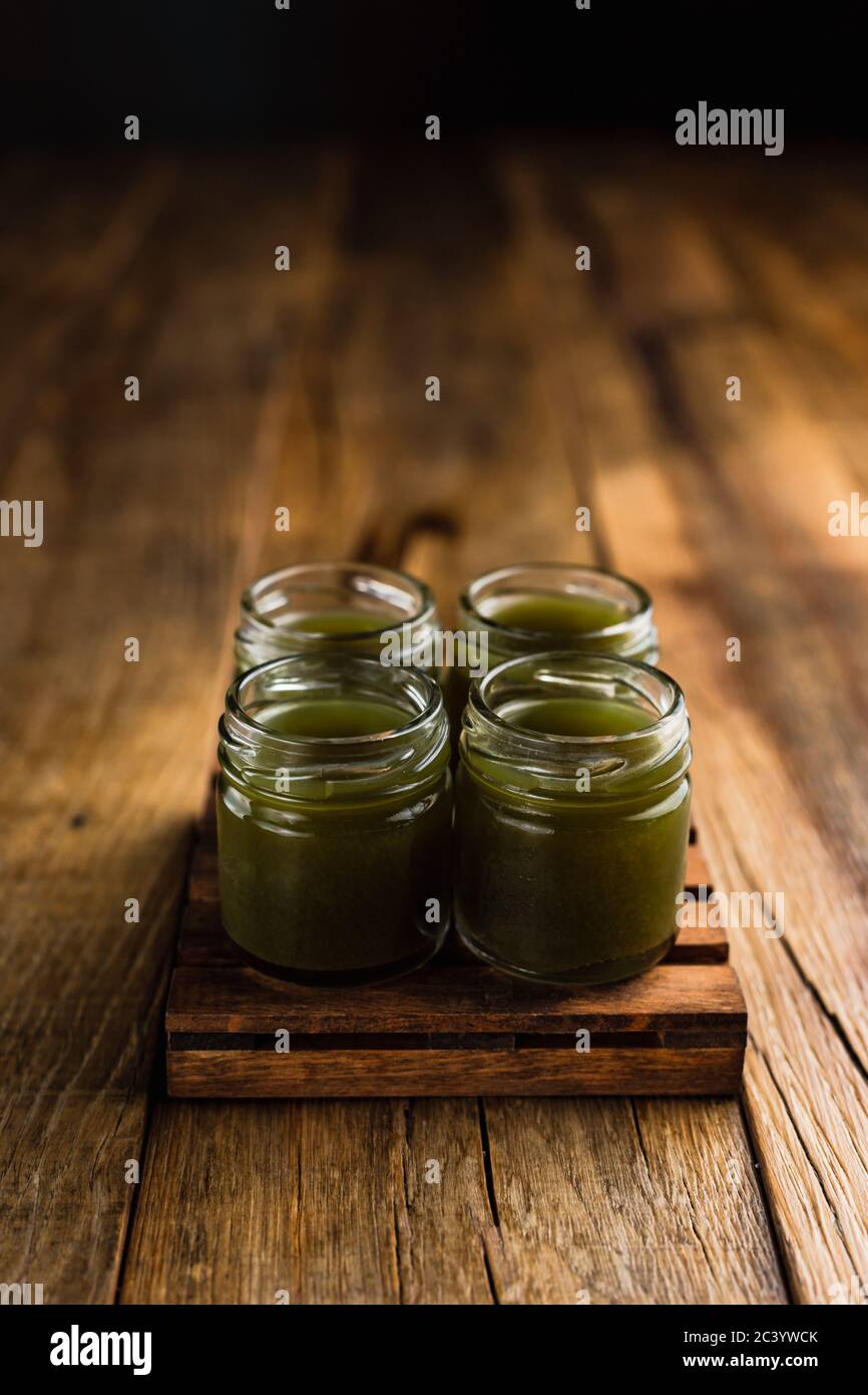 Green colored alcoholic shooters, or shot drinks on wooden table, copy ...