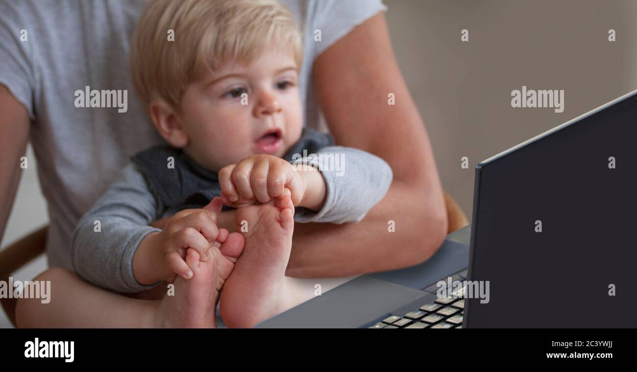 Little child looking excited and surprised at something on a laptop ...