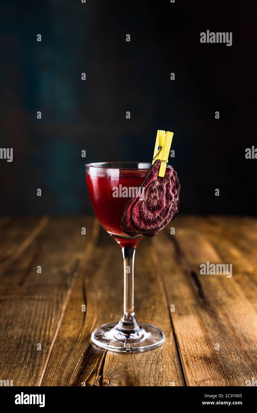 A classic red sour cocktail in a nick and nora glass garnished with a ...