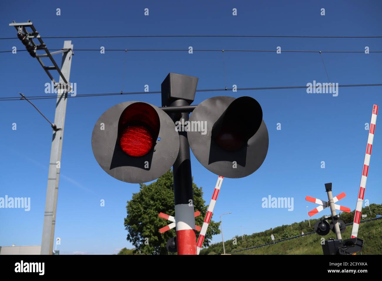 Red White barriers are coming down, bells ringing and red light at rail ...