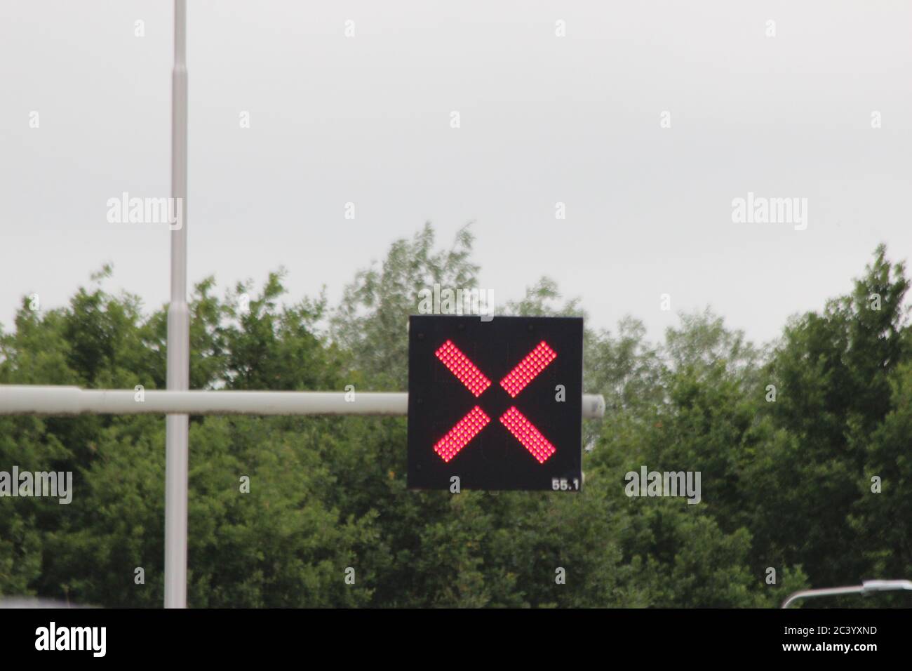 Red cross above a lane closed to traffic on a road Stock Photo - Alamy