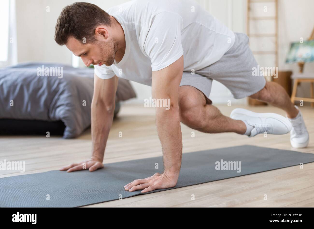 Sporty Man Training At Home Doing Running Plank Exercise Stock Photo ...