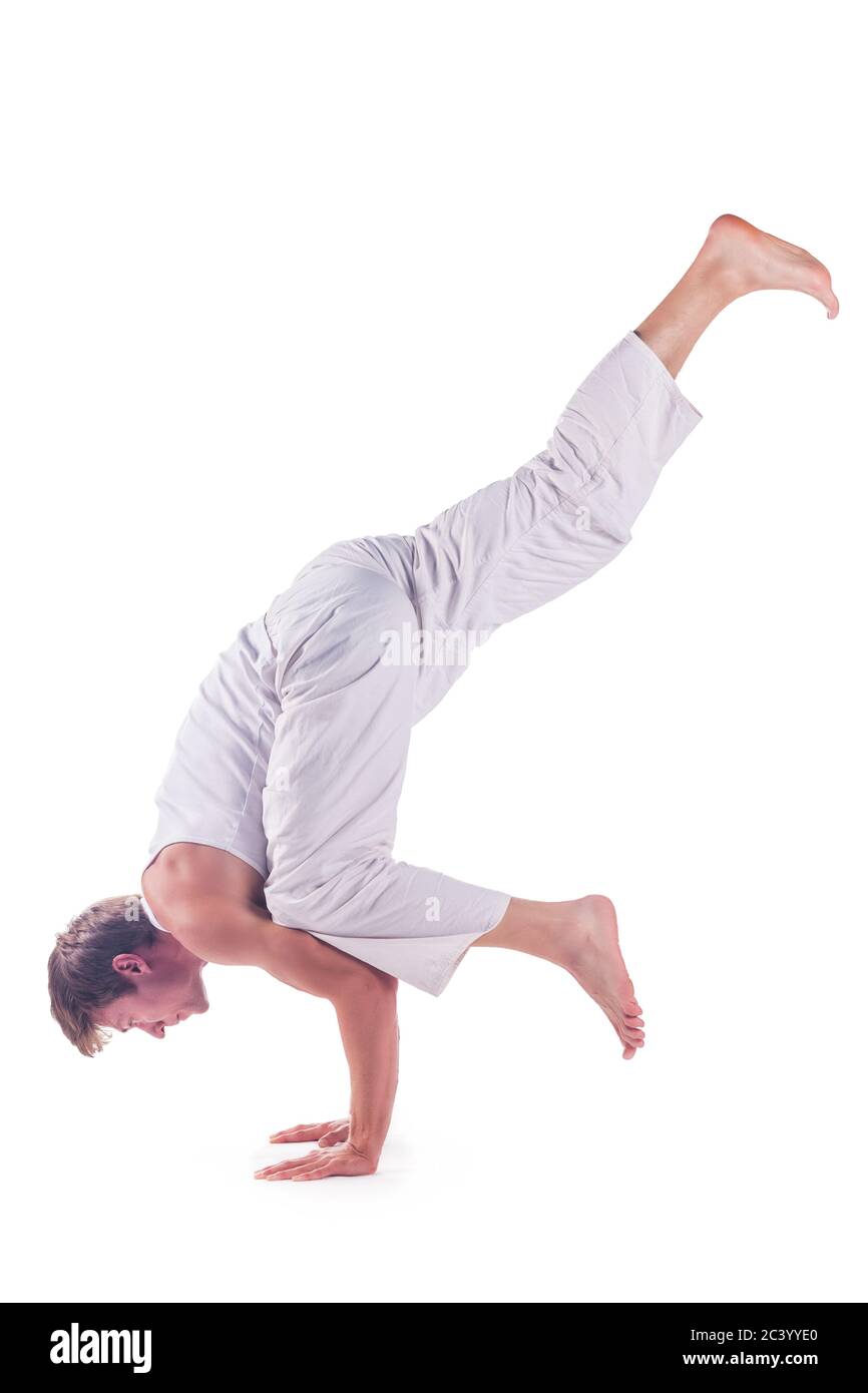 Man practicing yoga doing the " One-Legged Crane Pose " posture against ...