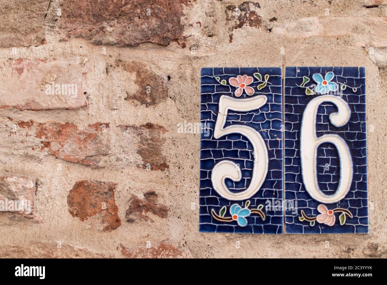Number 56 on the brown brick wall of a house in the historic center of ...