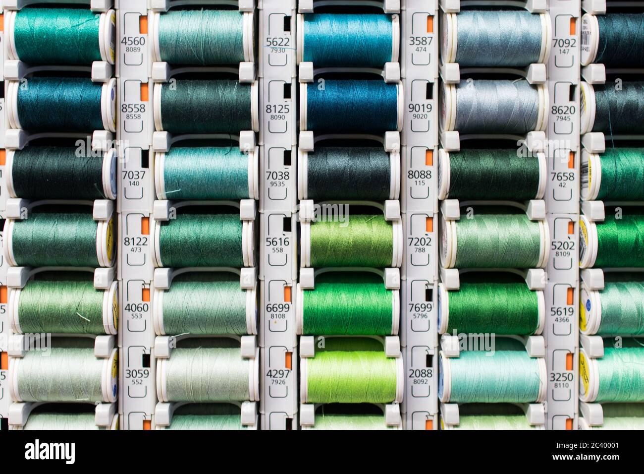 Colored spools of sewing thread exposed in a shelf dedicated to the ...
