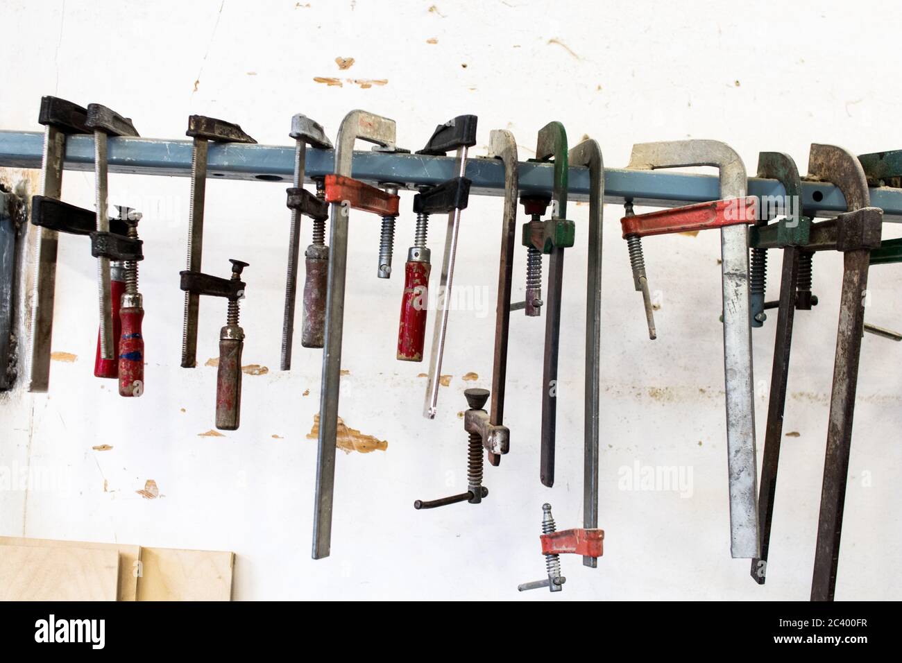 series of carpenter tools hung in the workshop. Clamps of various sizes ...