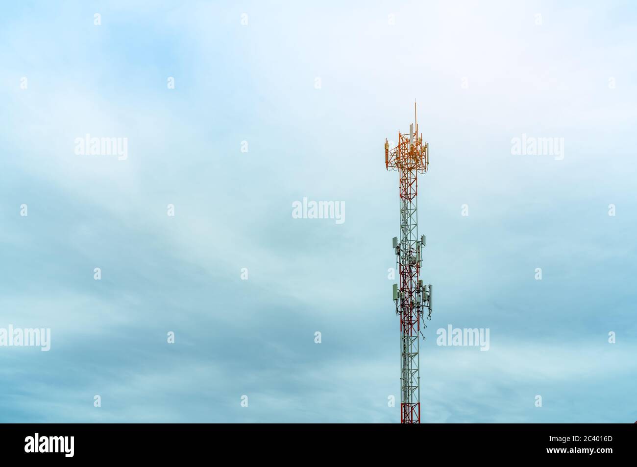 Telecommunication tower with blue sky and white clouds. Antenna on blue ...