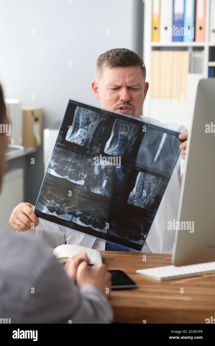 Doctor checking X-ray image during appointment with patient Stock Photo ...