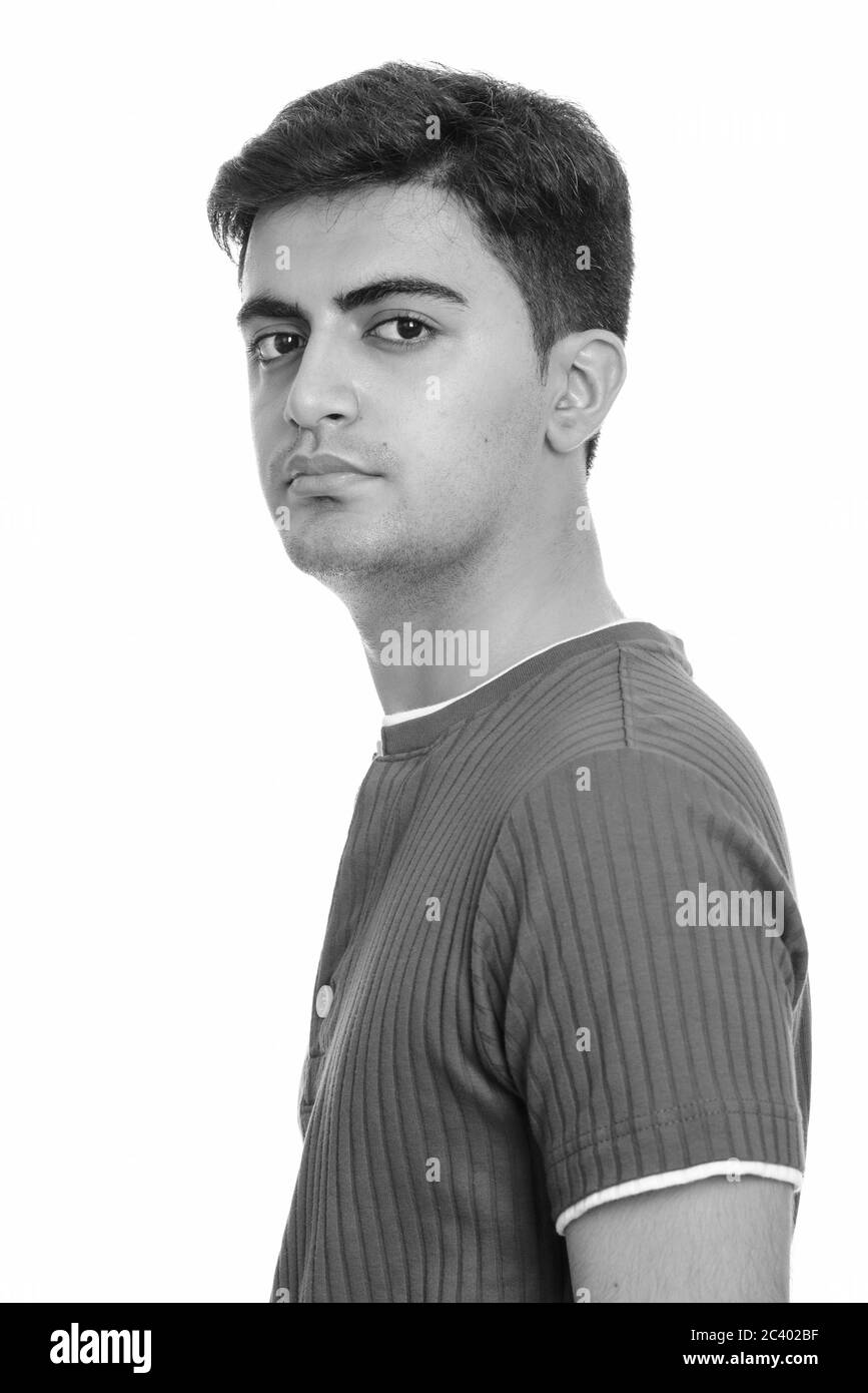 Profile view of young handsome Persian man looking at camera Stock ...
