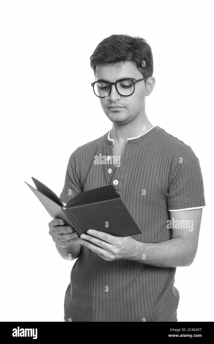 Portrait of young handsome Persian nerd man reading book Stock Photo ...