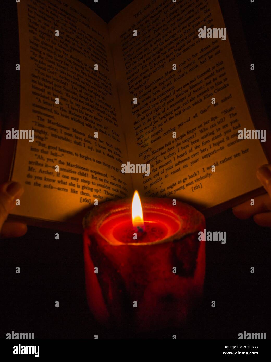 Reading a book by candlelight Stock Photo - Alamy