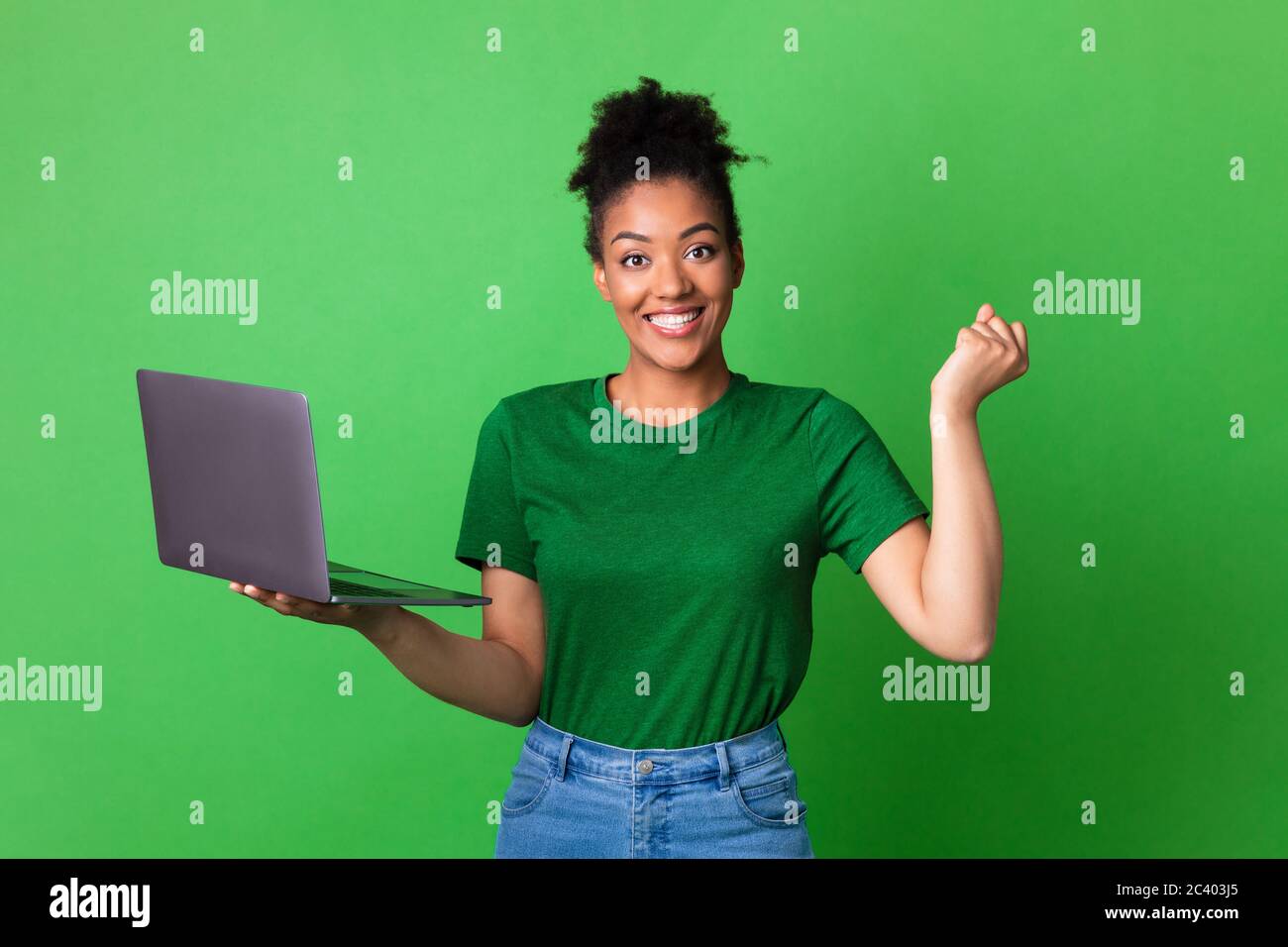 Excited female employee feeling ecstatic holding pc Stock Photo - Alamy