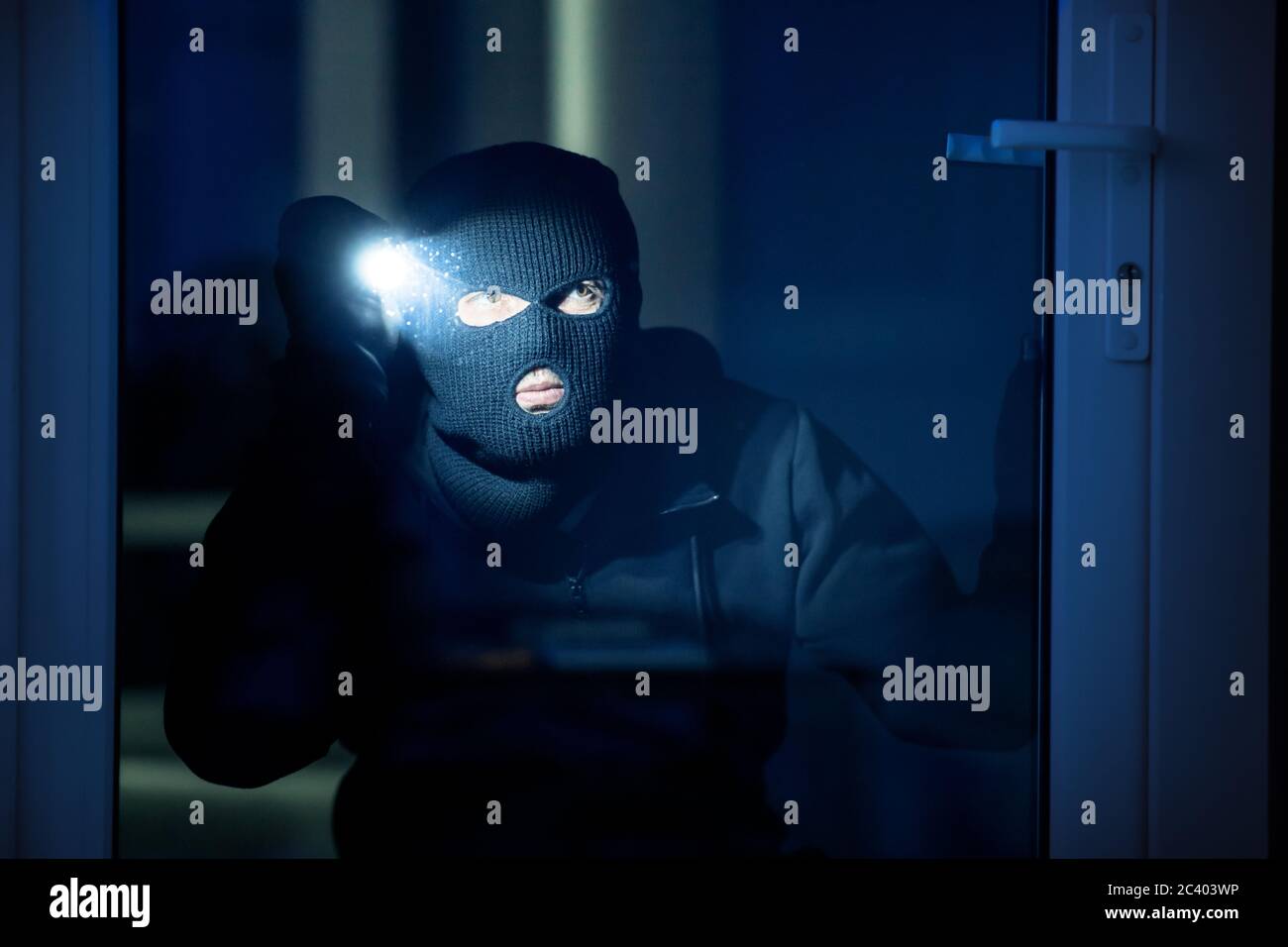 Intruder breaking in apartment or office using flash light Stock Photo ...