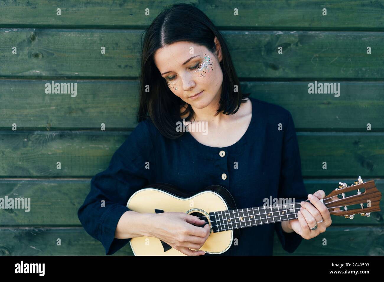 A young girl is playing ukulele Stock Photo - Alamy