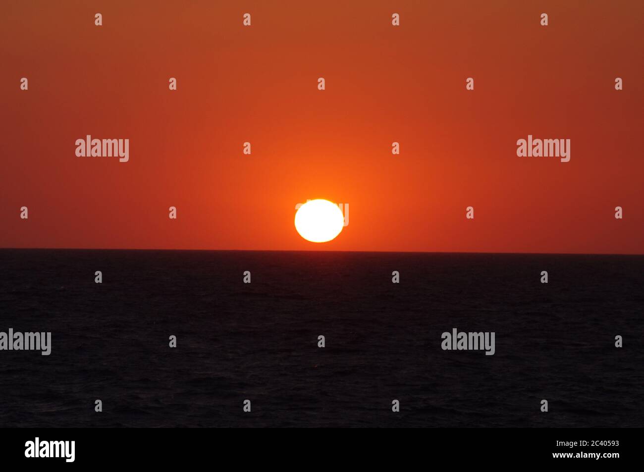 Series of images of sunsetting over ocean,Yellow orb sinking into the ...