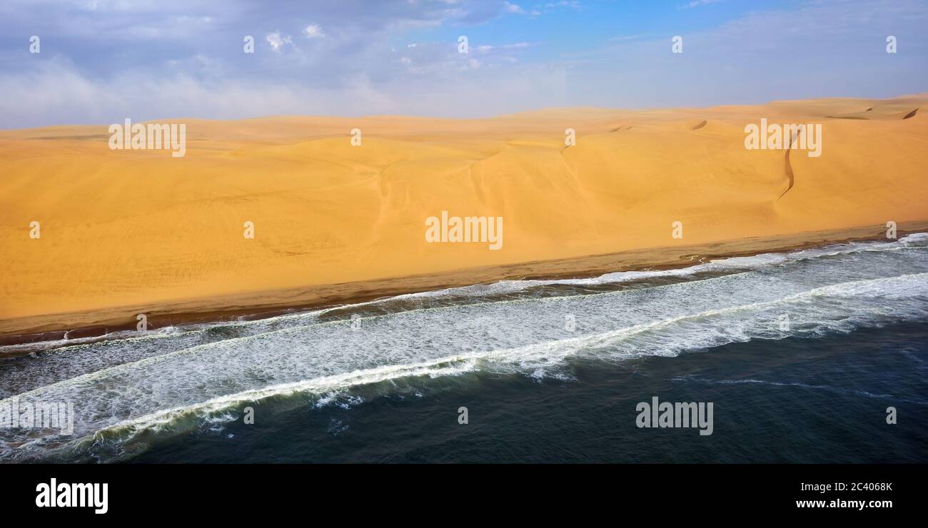 Aerial view on the coast in Namibia where dunes of the Namib desert ...
