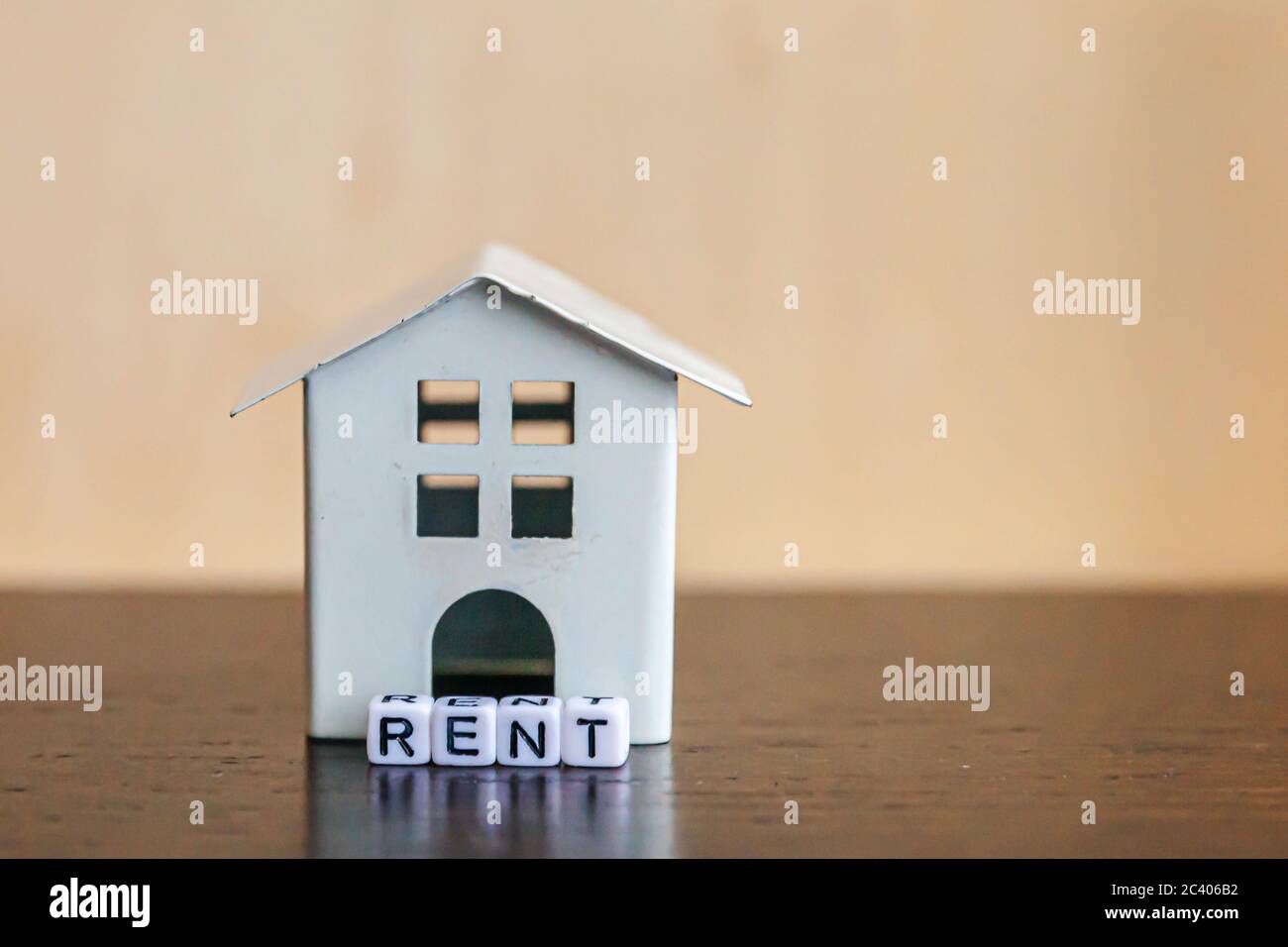 Miniature toy model house with inscription RENT letters word on wooden ...