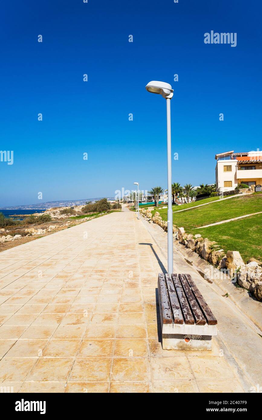 Bench on the promenade along the Mediterranean coast with Hotels. The ...