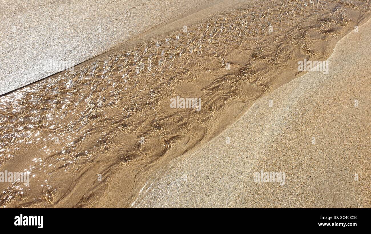 Sand and water Stock Photo - Alamy