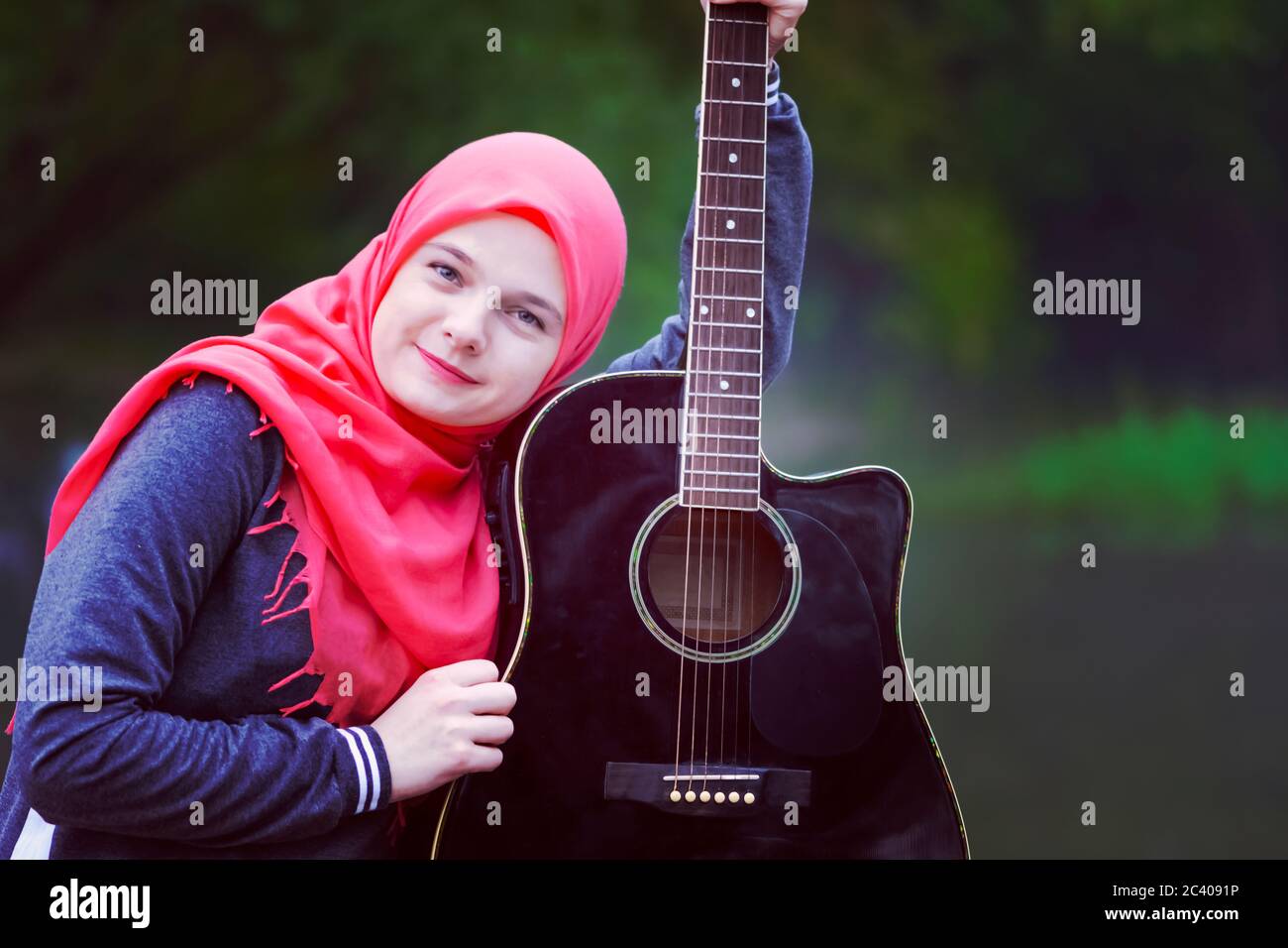 Portrait of blue eyed muslim girl holding guitar Stock Photo - Alamy