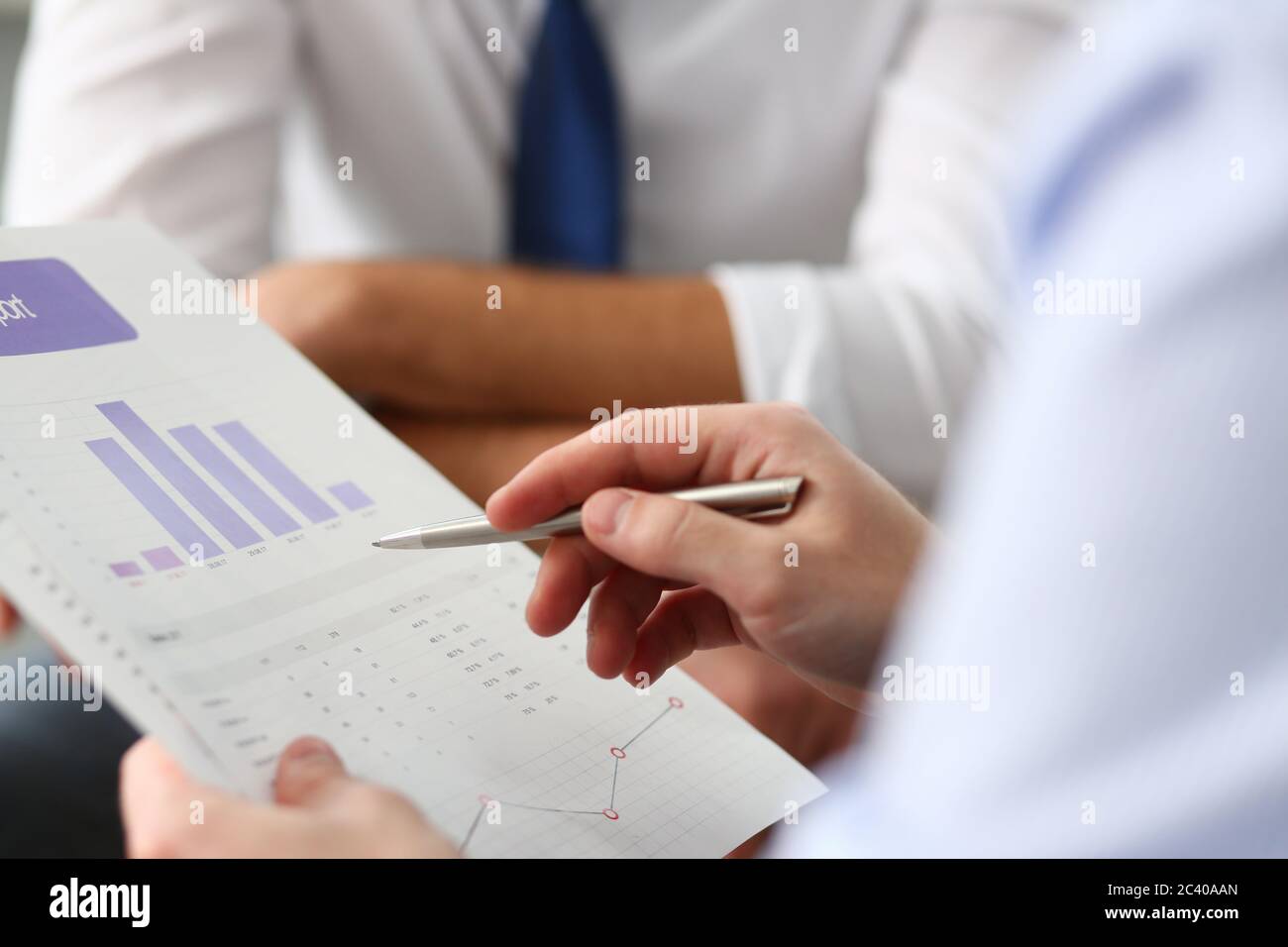 Business people discussing statistics report at work Stock Photo - Alamy