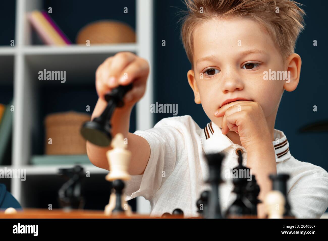 Close up photo of a little boy playing chess Stock Photo - Alamy