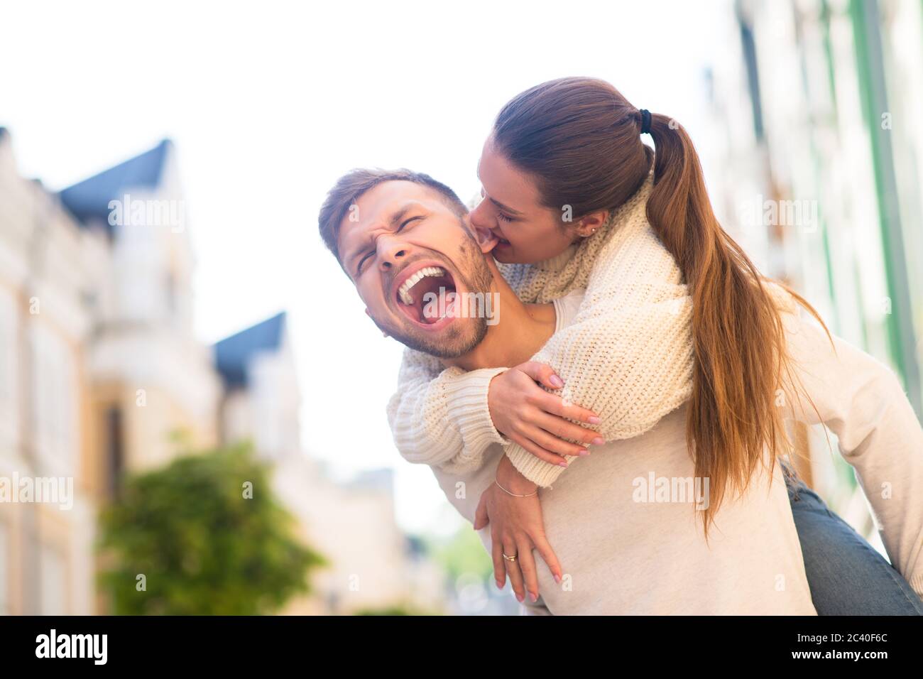 Emotional man holding a woman behind her back Stock Photo - Alamy