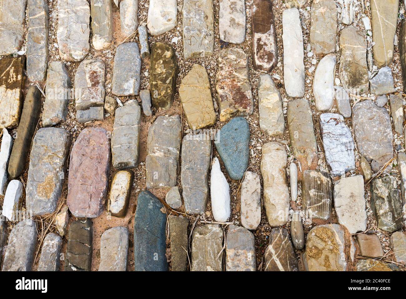 Multi-colored stones on the ground. Different shapes and sizes. Texture ...