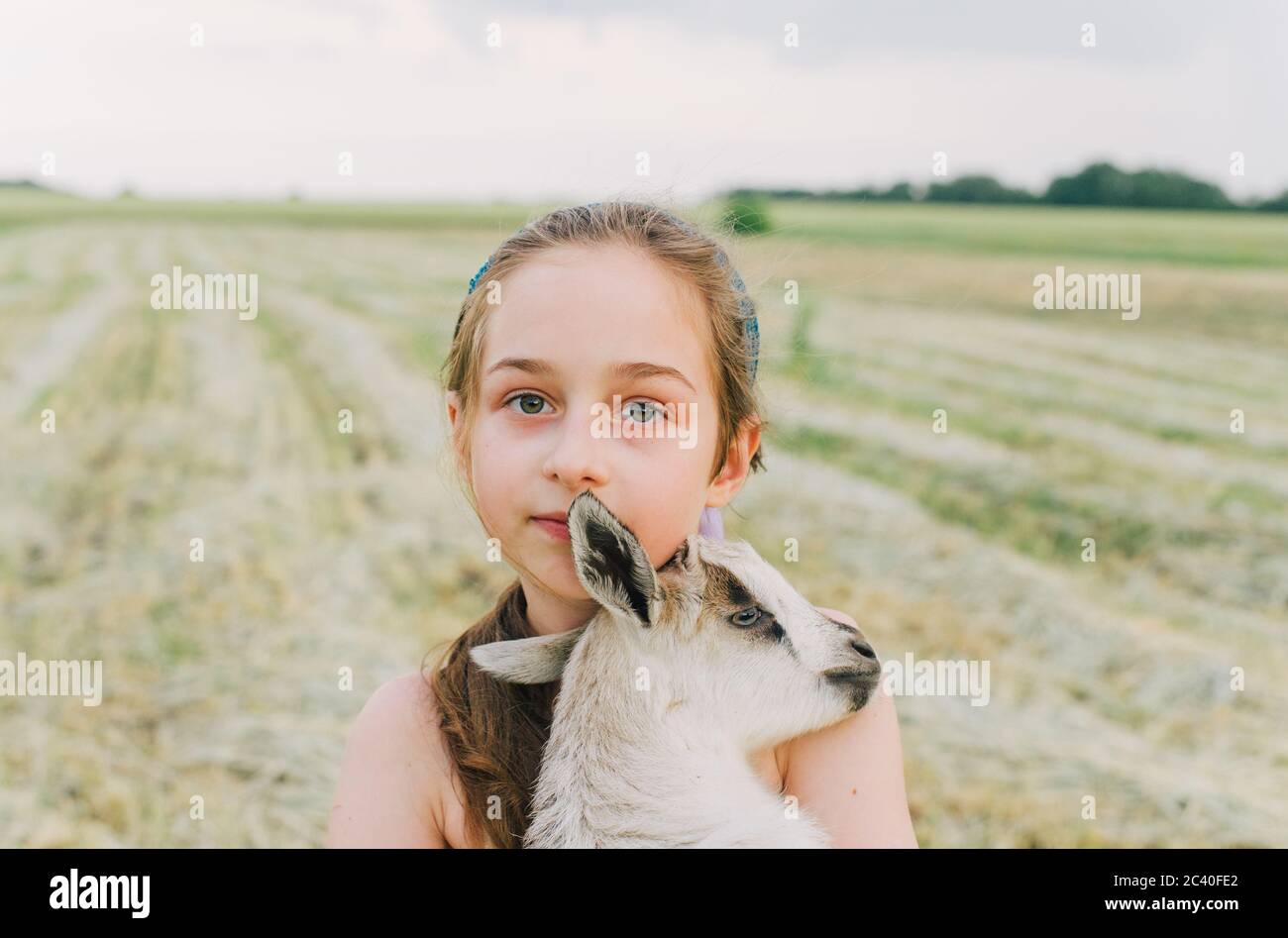 girl with baby goat on farm outdoors. Love and care. Village animals ...