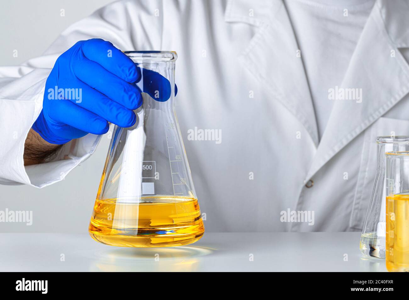 Chemist pouring yellow liquid in hi-res stock photography and images ...
